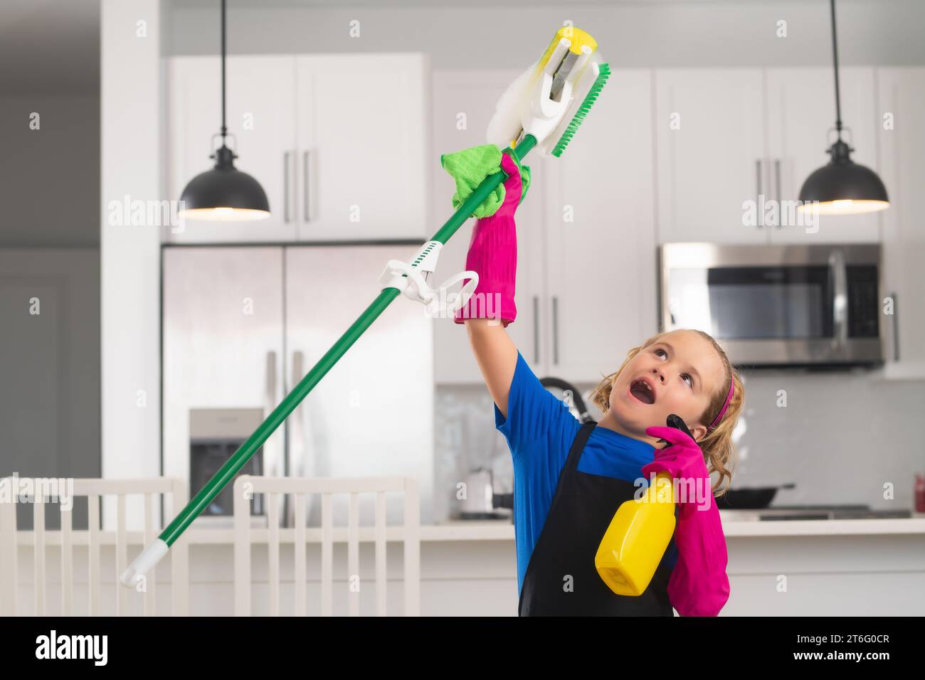 Housekeeping, home chores. Child use duster and gloves for cleaning ...