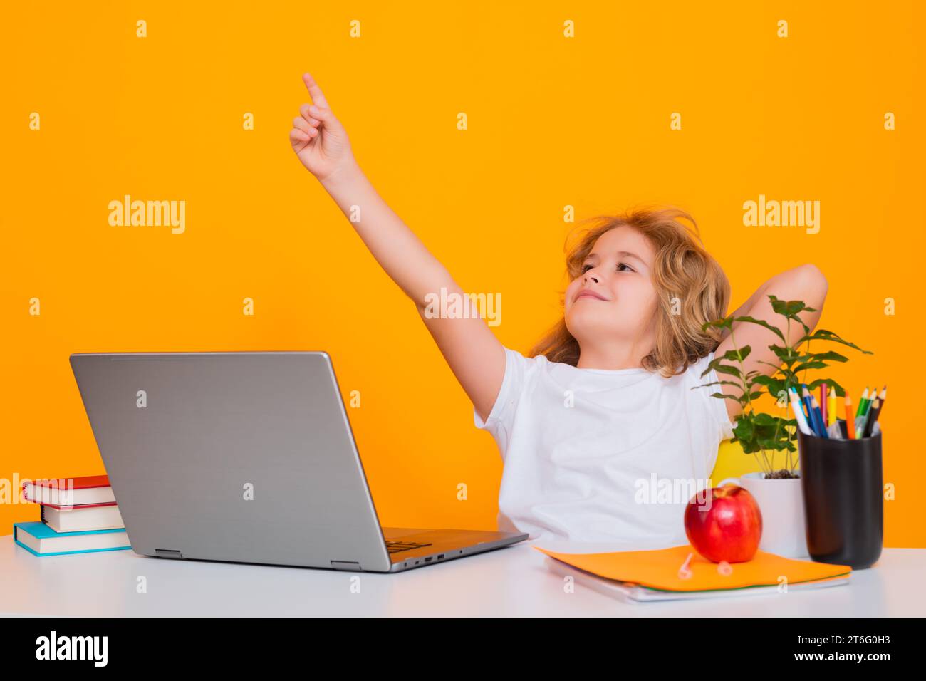 School child using laptop computer. School kid holding index finger up ...