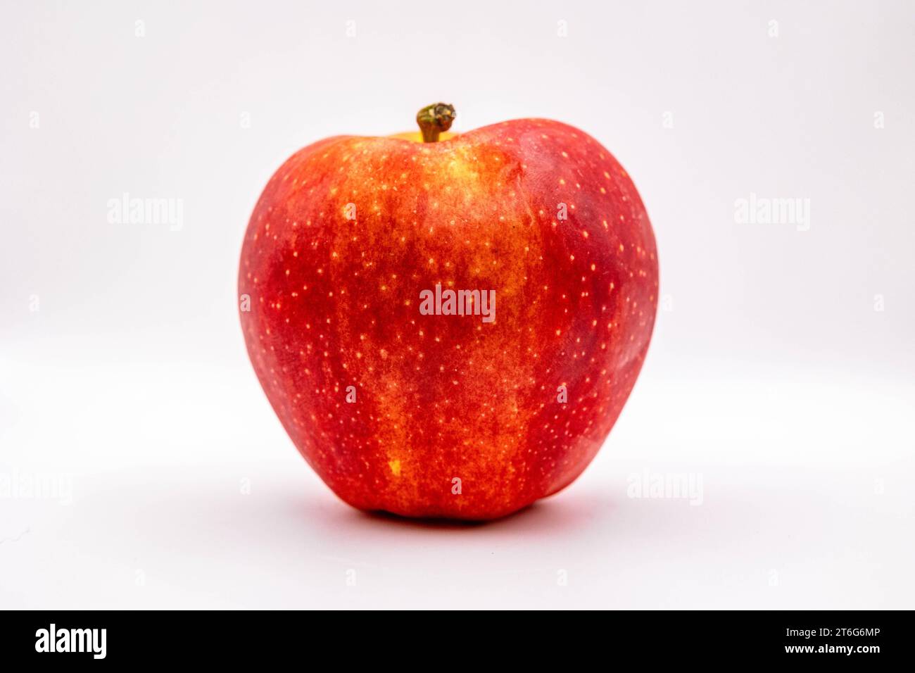 A fresh, ripe, bright red apple on a pristine white background, ready ...