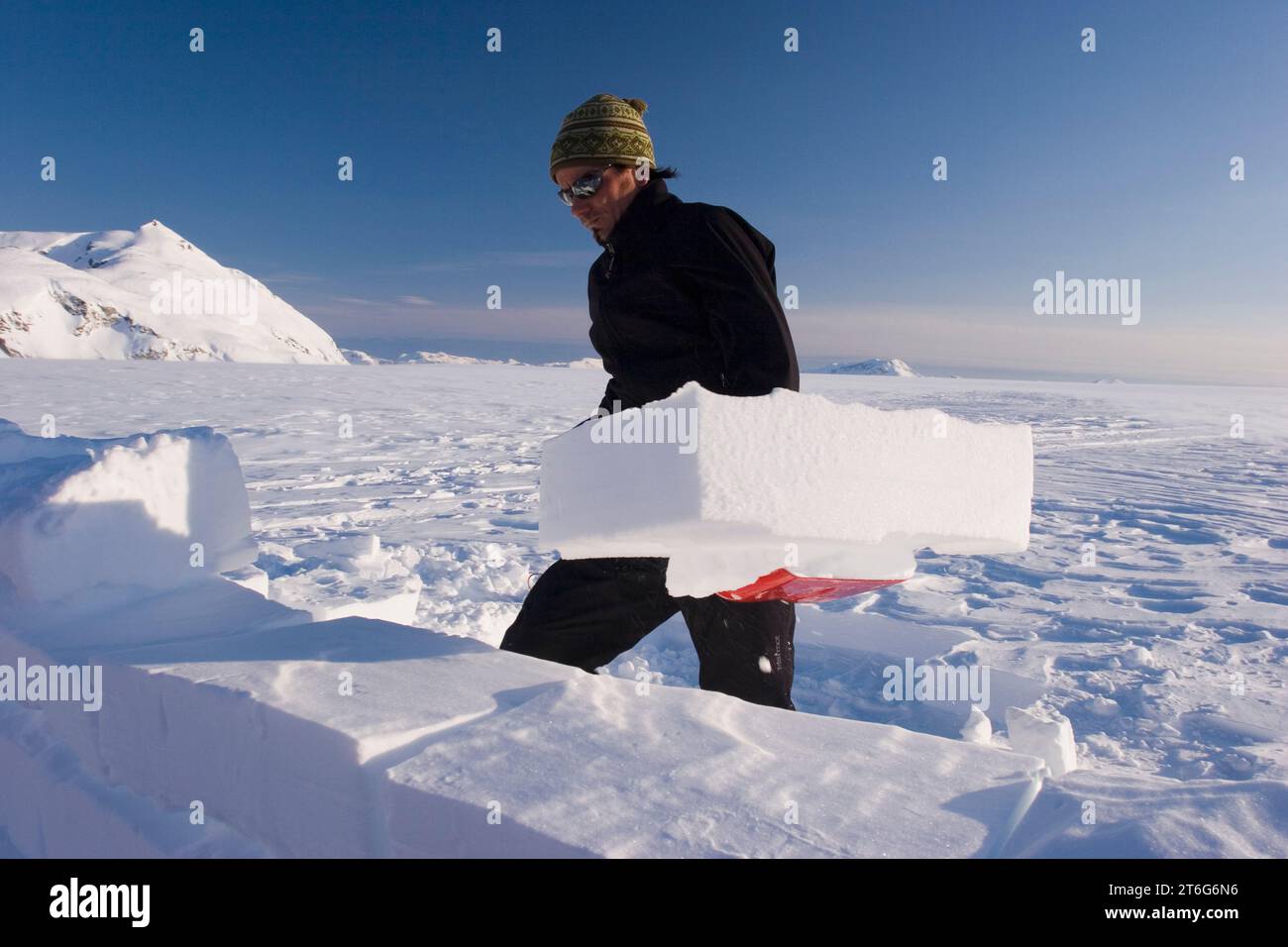 Glacial geology PhD student builds a wall of snow blocks around his ...