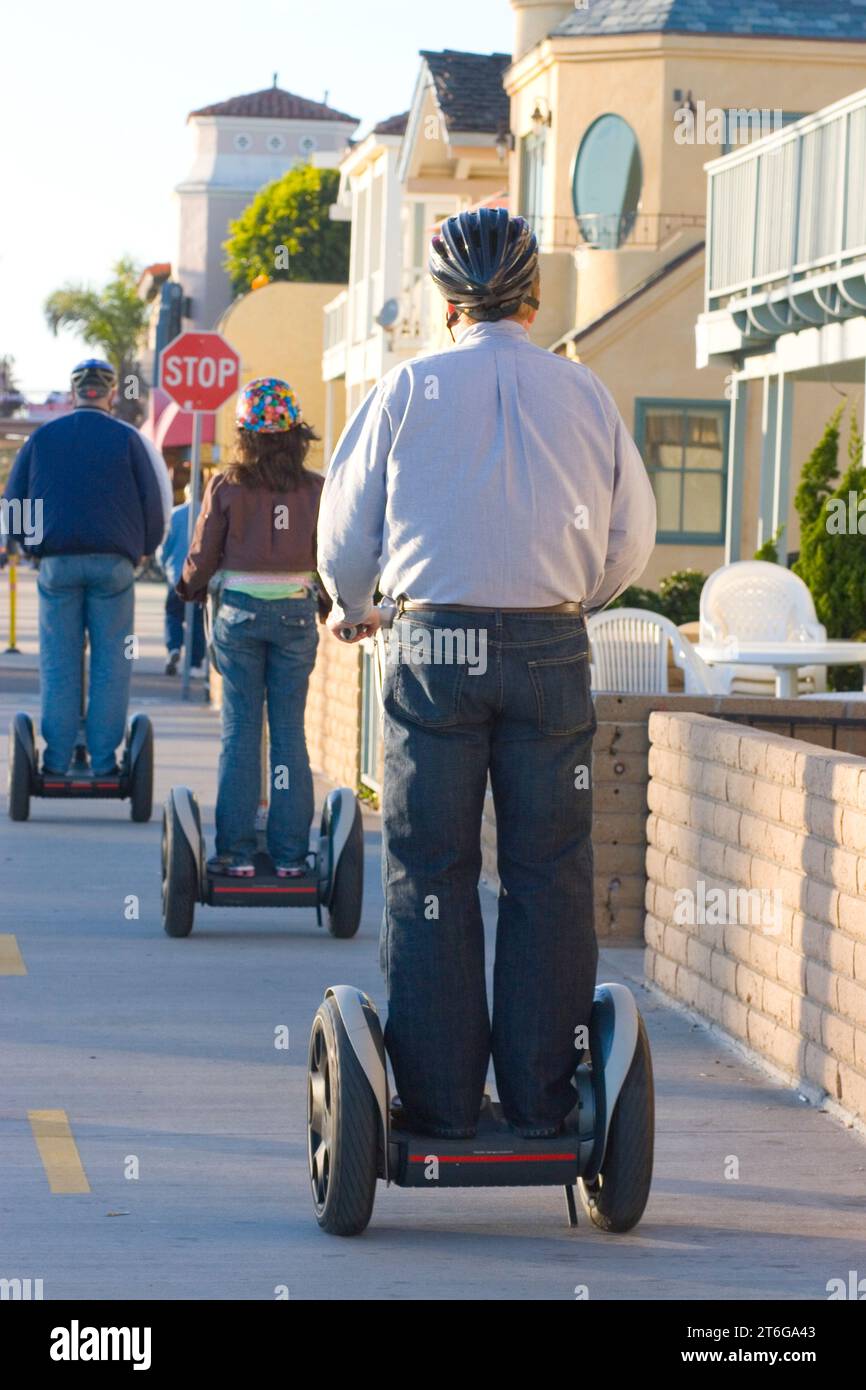 Visitors to the boardwalk at Newport Beach, California ride the segway ...