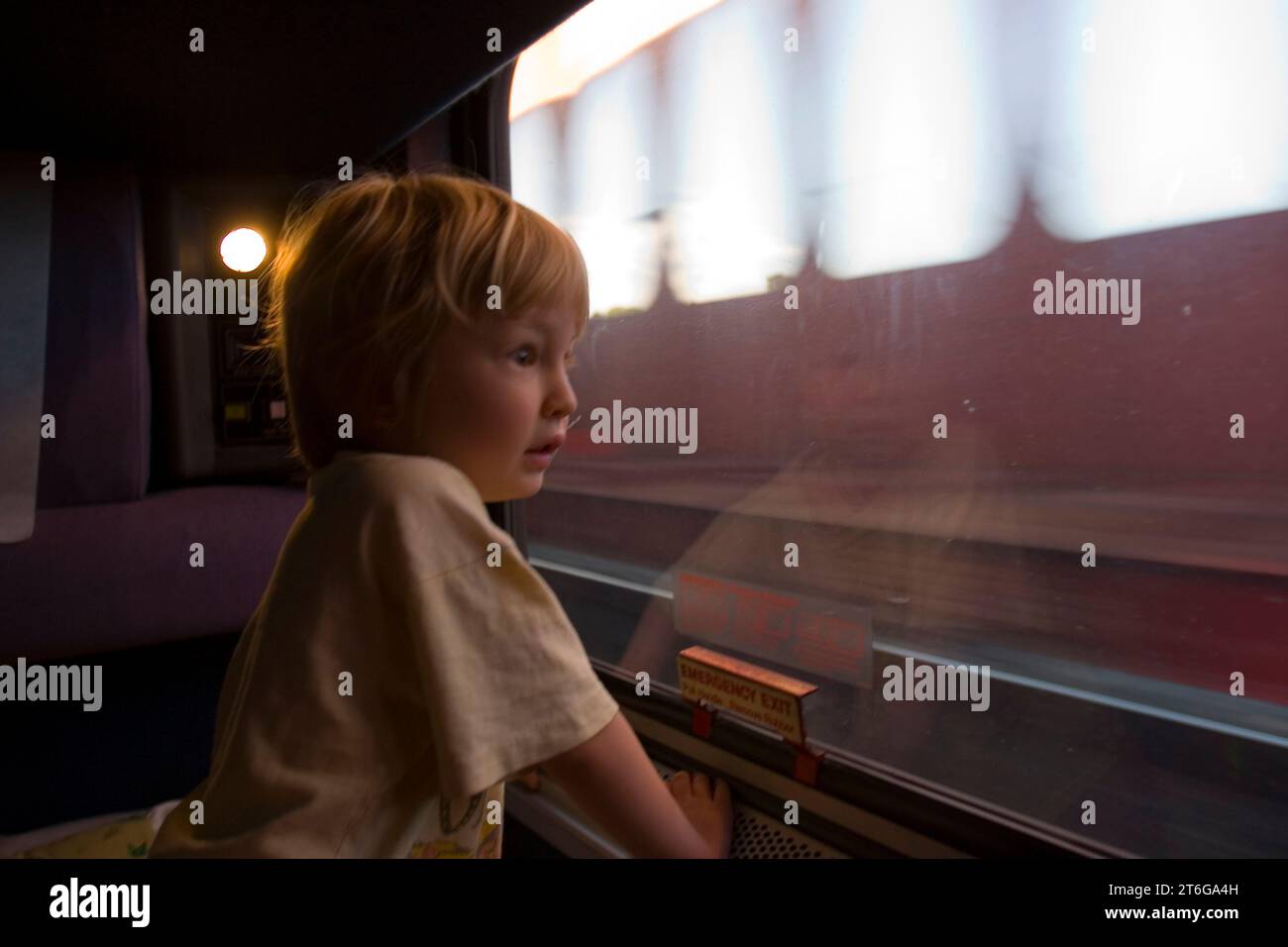 A little boy looks out of a train window Stock Photo - Alamy