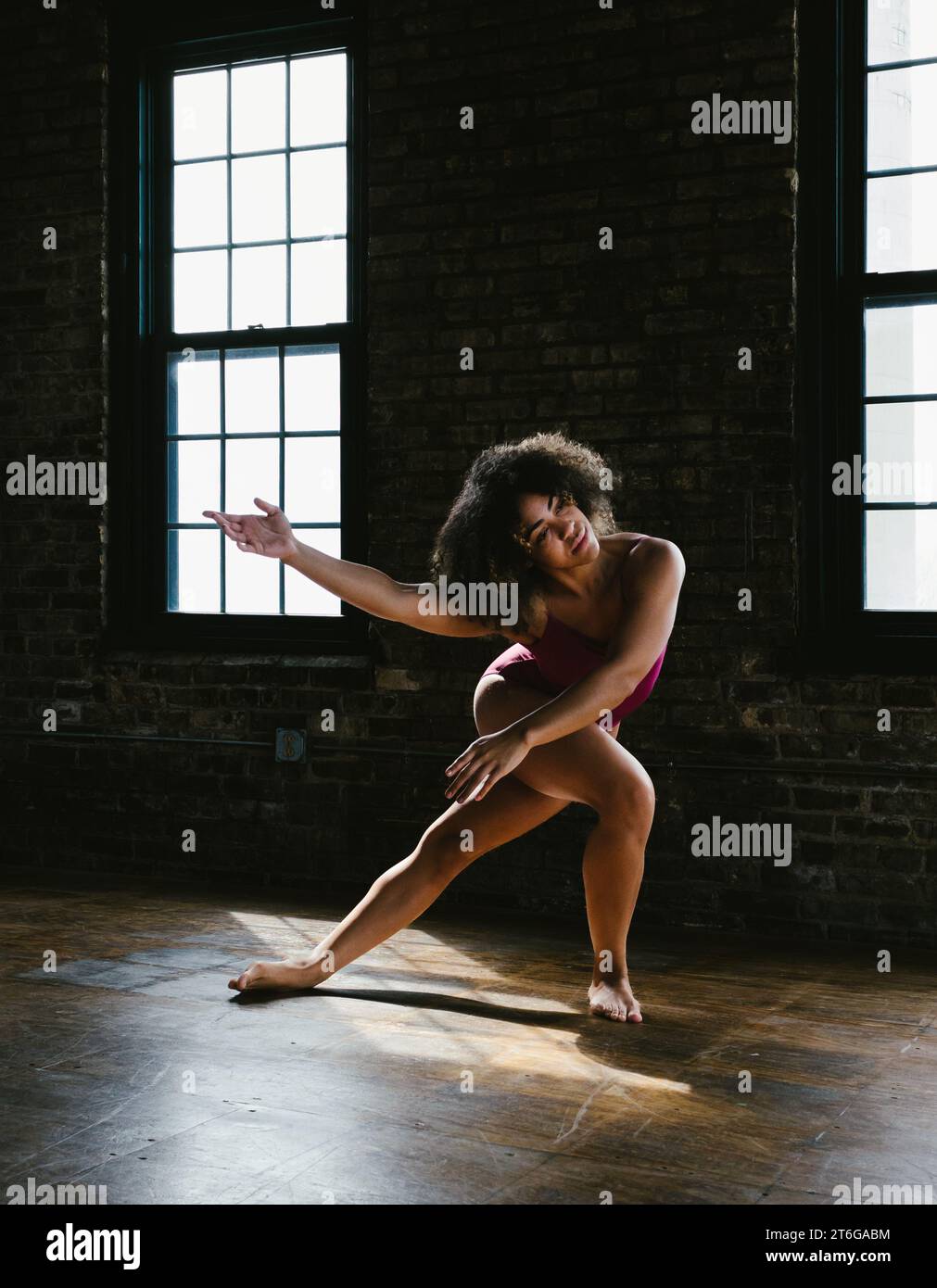 Mixed race female dancing contemporary pose with window light Stock Photo - Alamy
