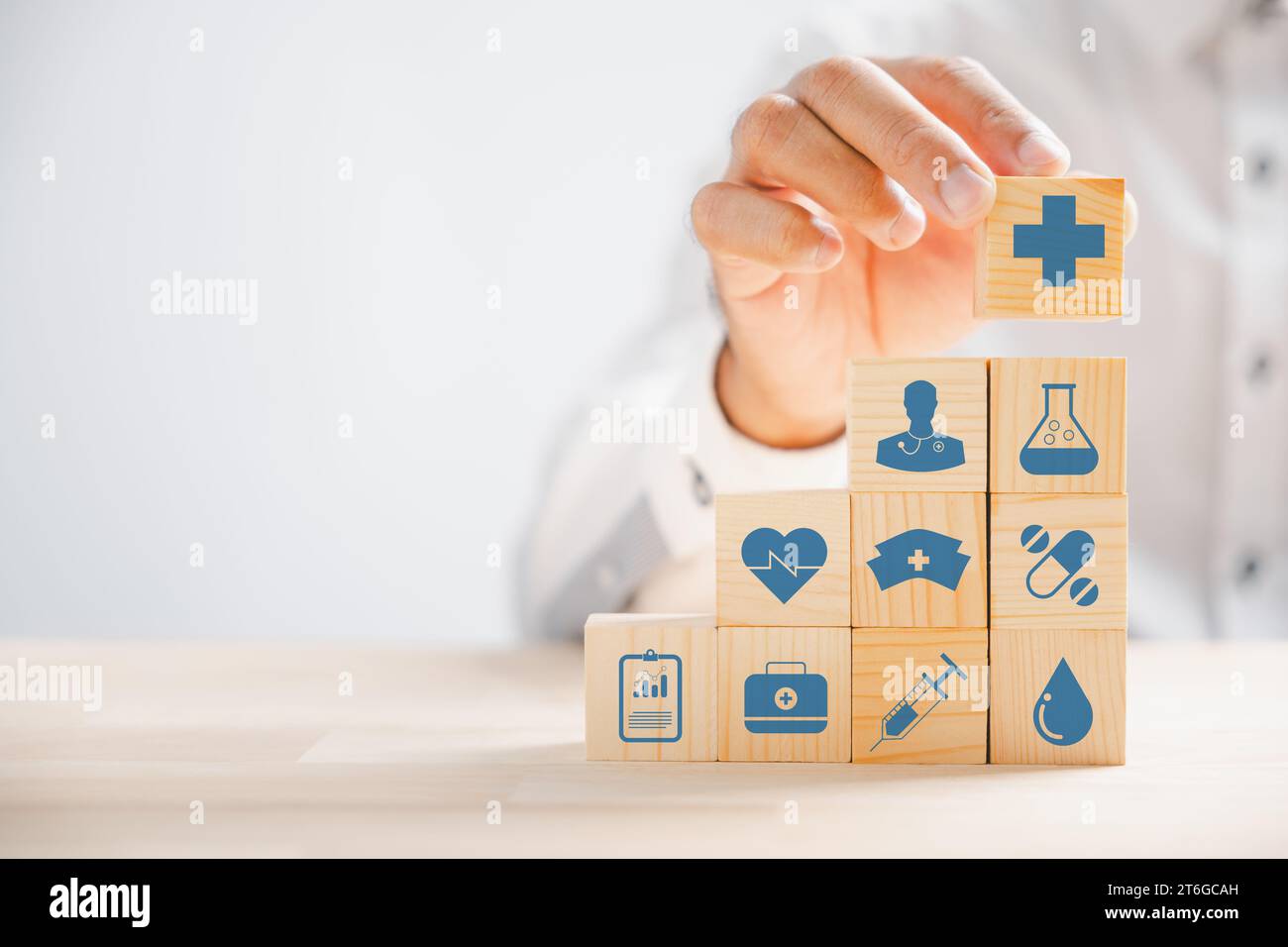 Hand hold wooden block with icon healthcare medical Stock Photo - Alamy