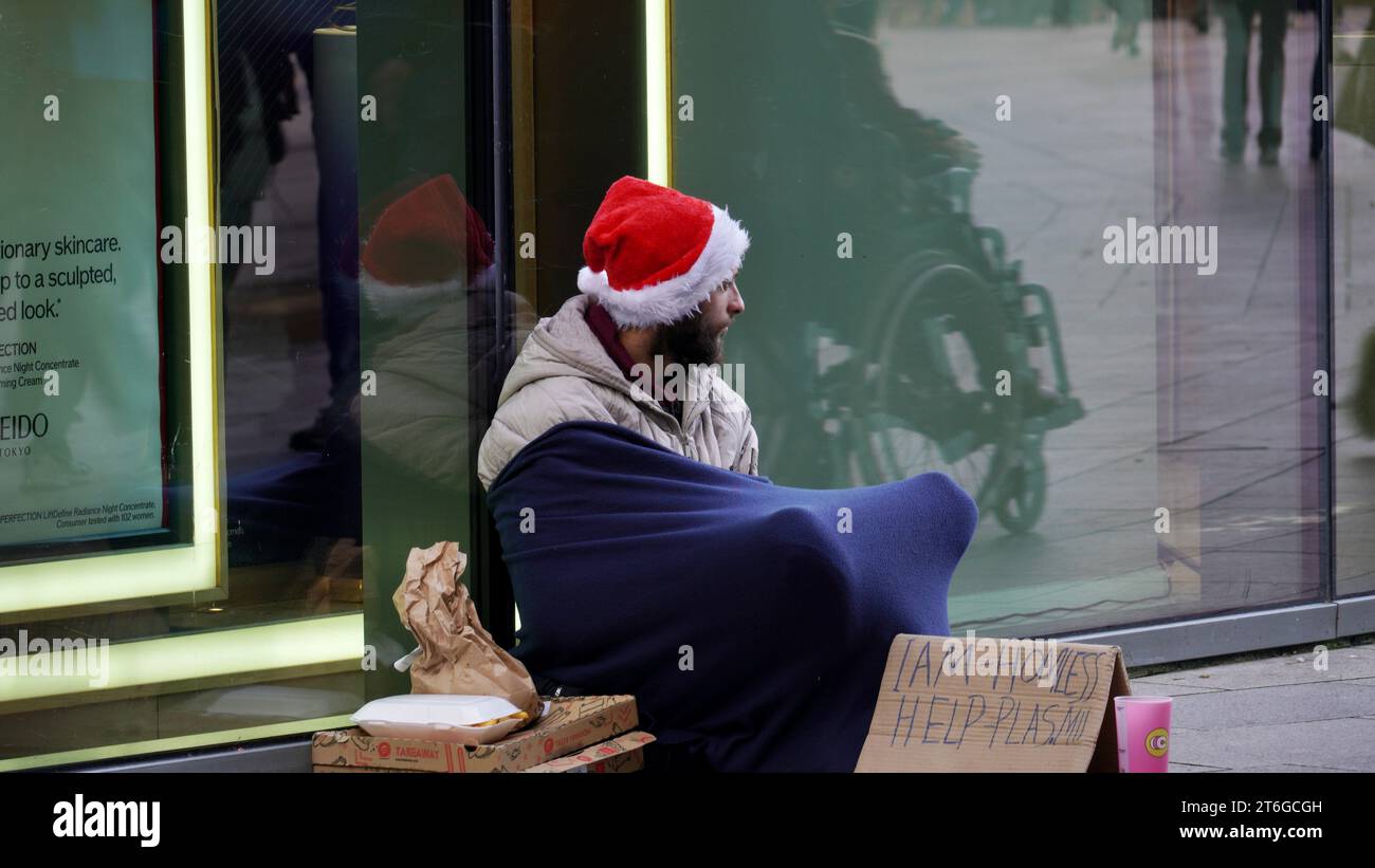 Destitution in the city centre of Cardiff. A homeless man with a sign ...