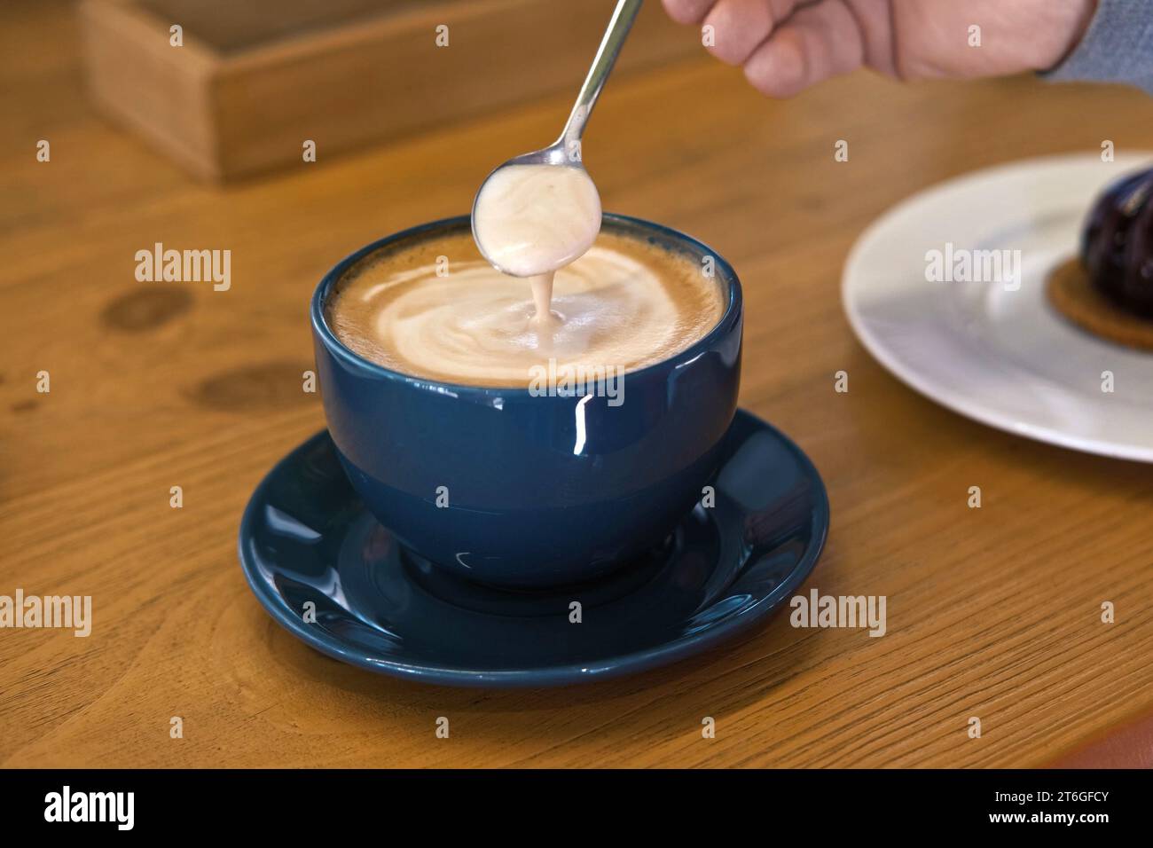 Hand is Mixing the Milk Foam of Latte. Person Stirring Cappuccino with ...