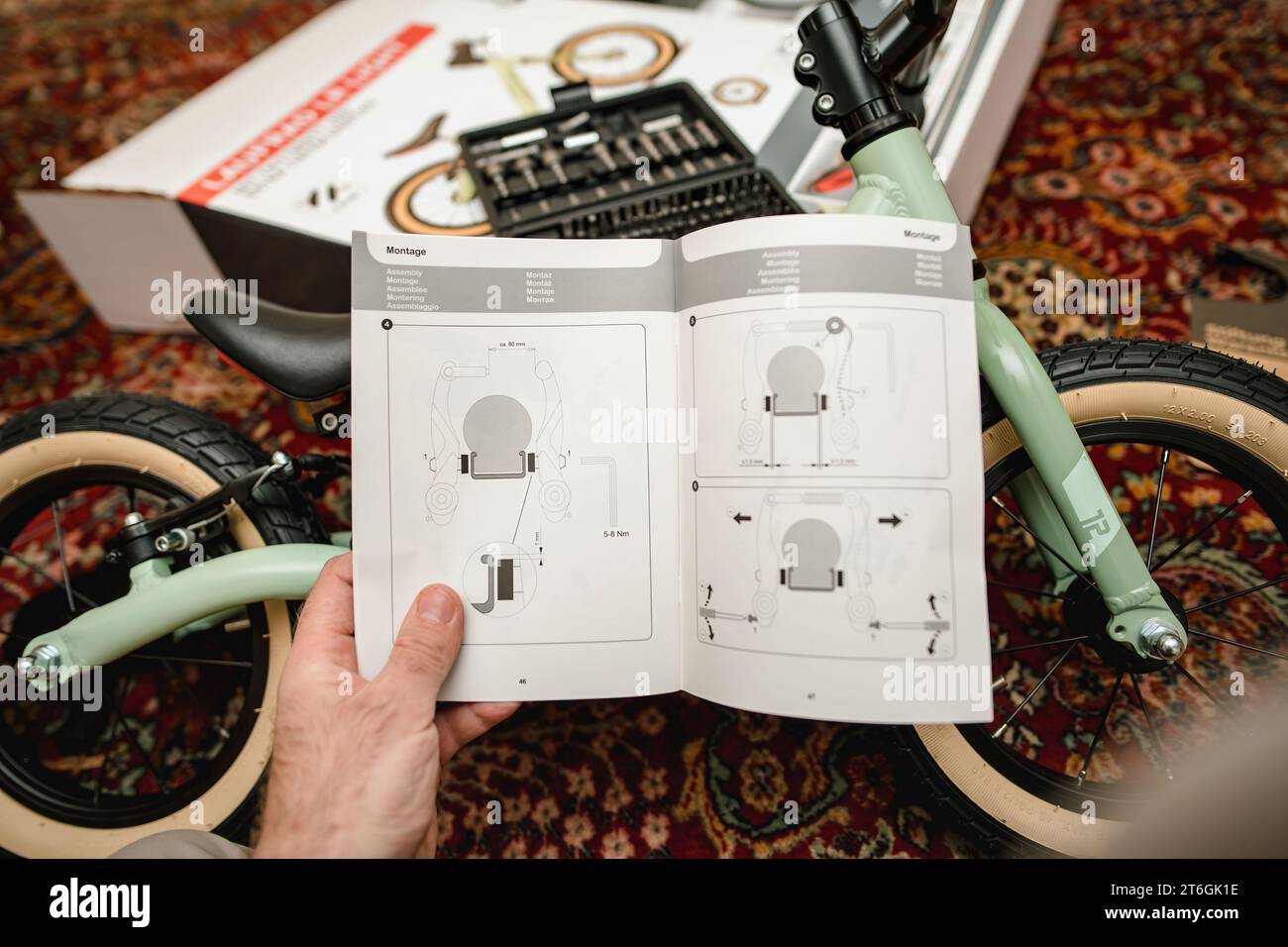 A moment captured as a male hand attentively reads the assembly instructions for a new bike ...