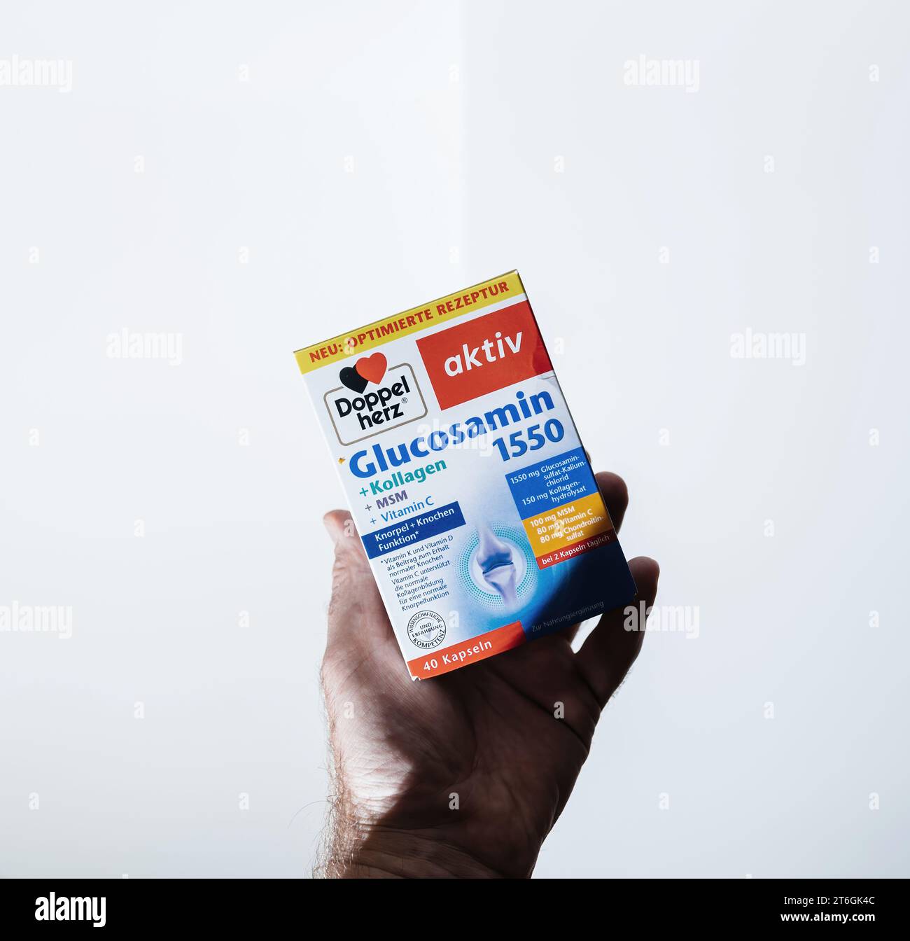 A male hand holding a package of Doppel Herz Glucosamine 1550 vitamins ...
