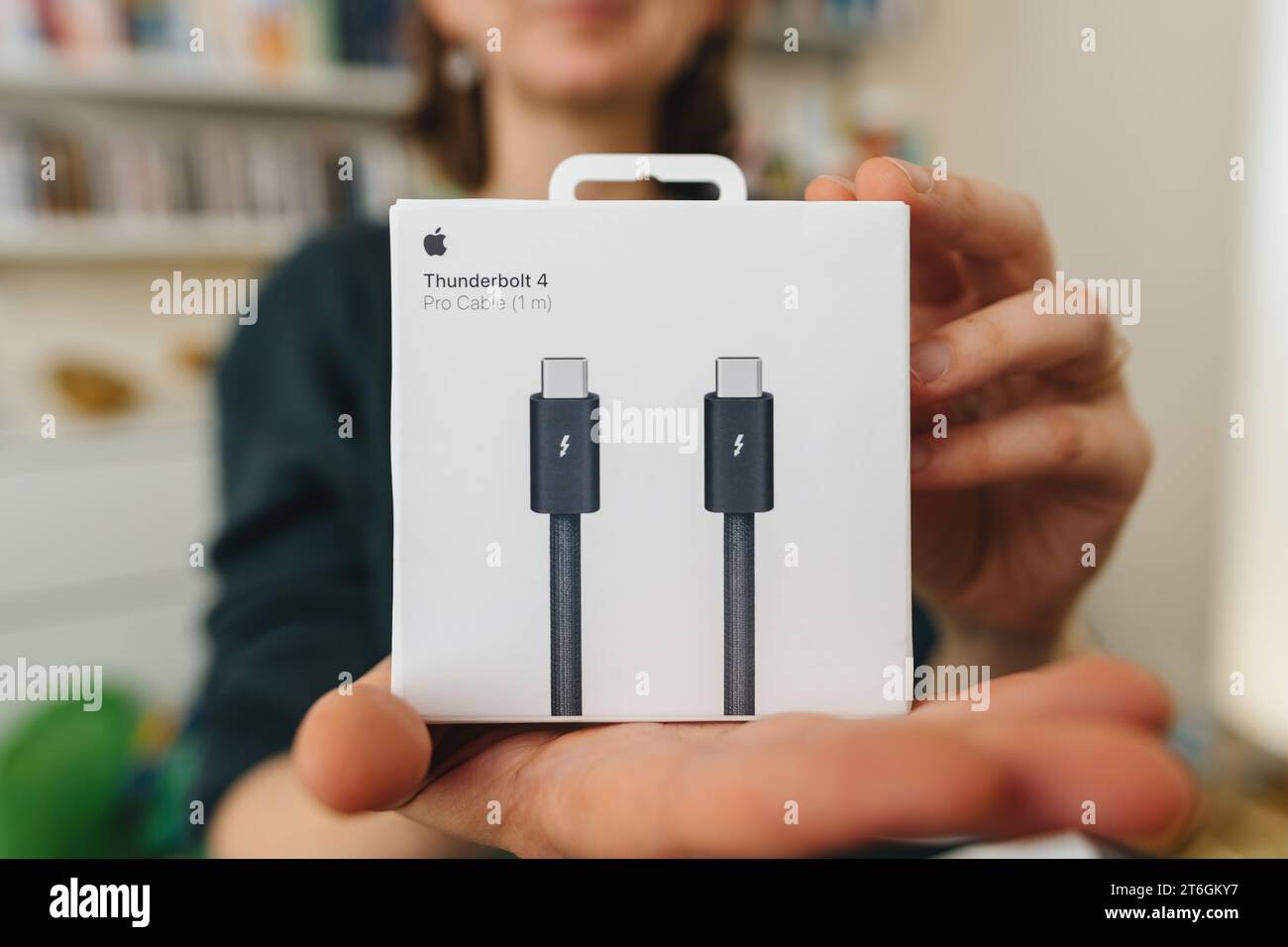 A person holding the retail box of an Apple Thunderbolt 4 Pro Cable ...