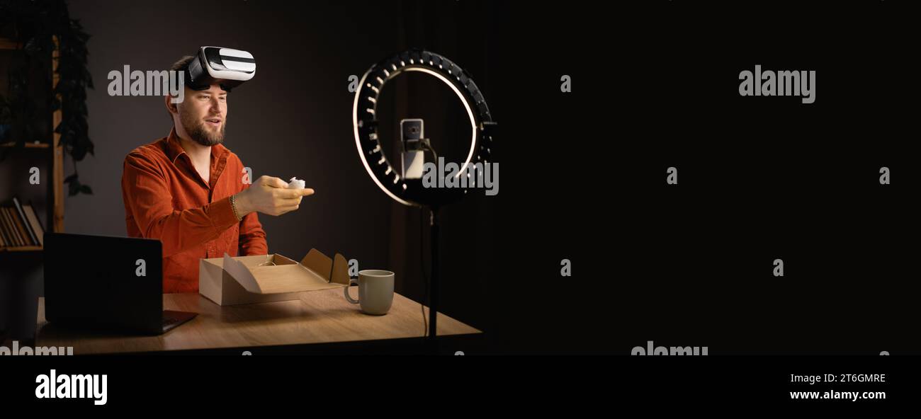 Handsome tech blogger male influencer unboxing device using modern ...