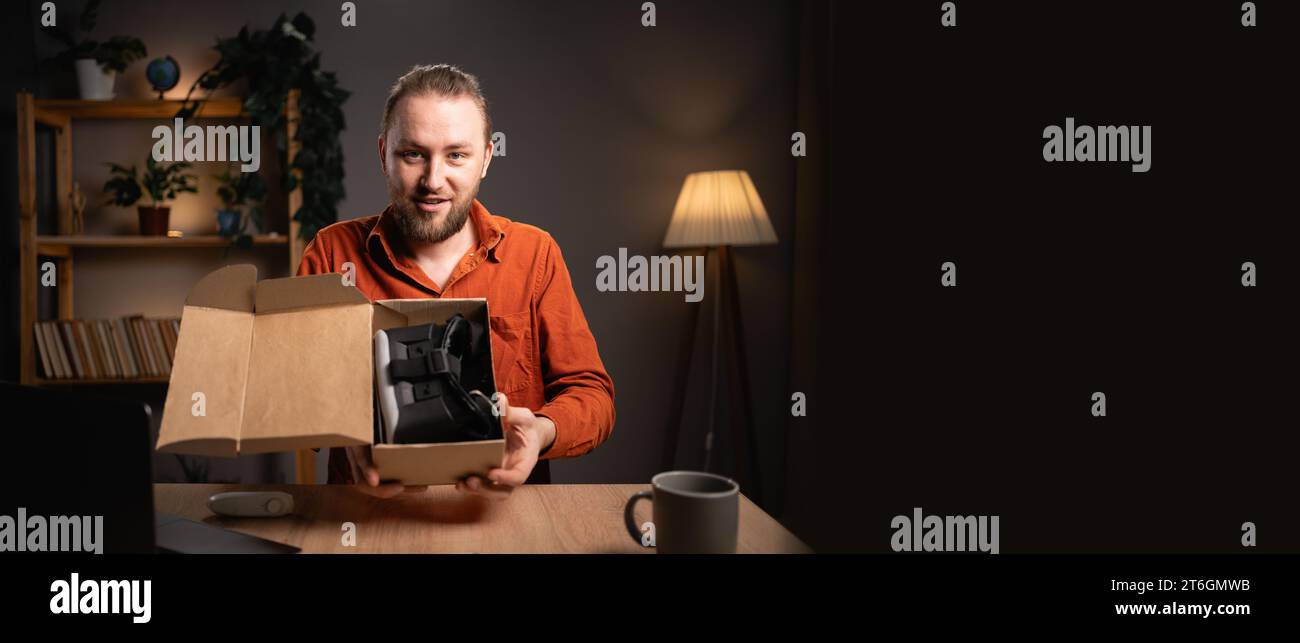 Tech product review. Male blogger unboxing parcel with VR Glasses at ...