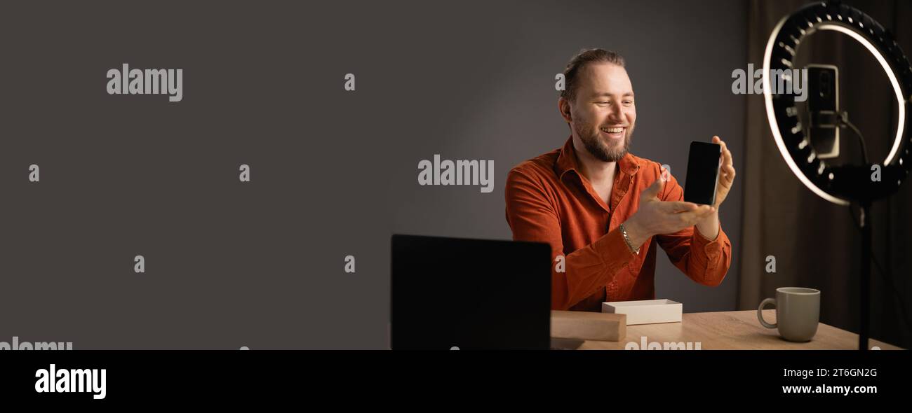 Tech male vlogger doing unpacking review video of mobile phone while ...