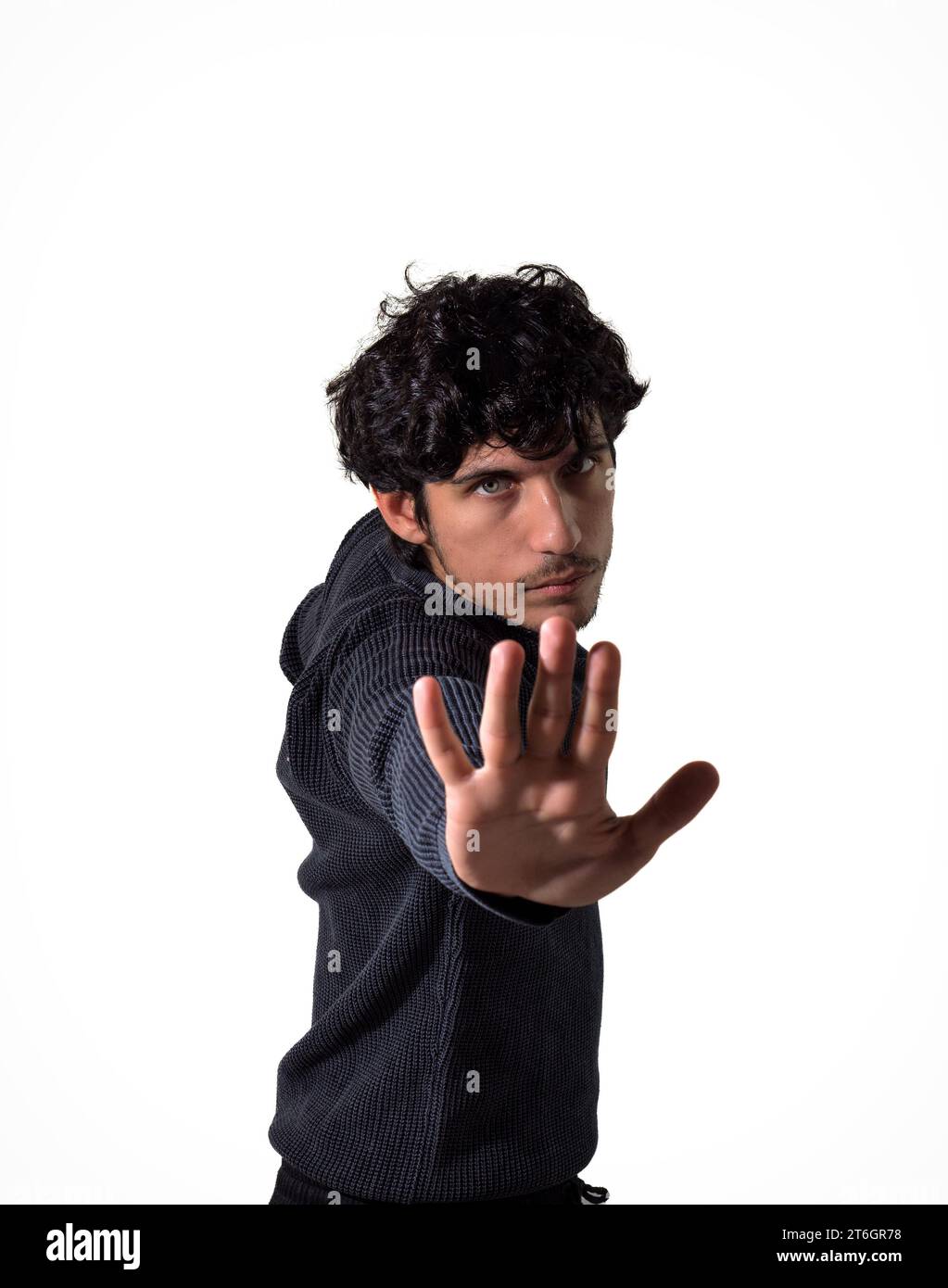 A man making a stop sign with his hands, towards the camera, in studio ...