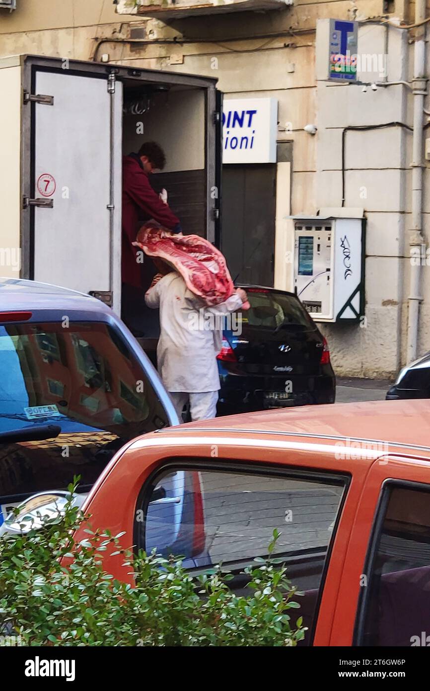 Meat arrives in the city center for the butcher shop, Two men unload ...
