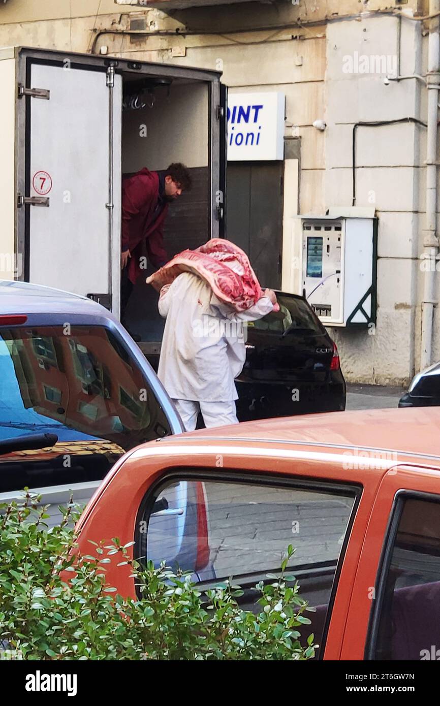 Meat arrives in the city center for the butcher shop, Two men unload ...