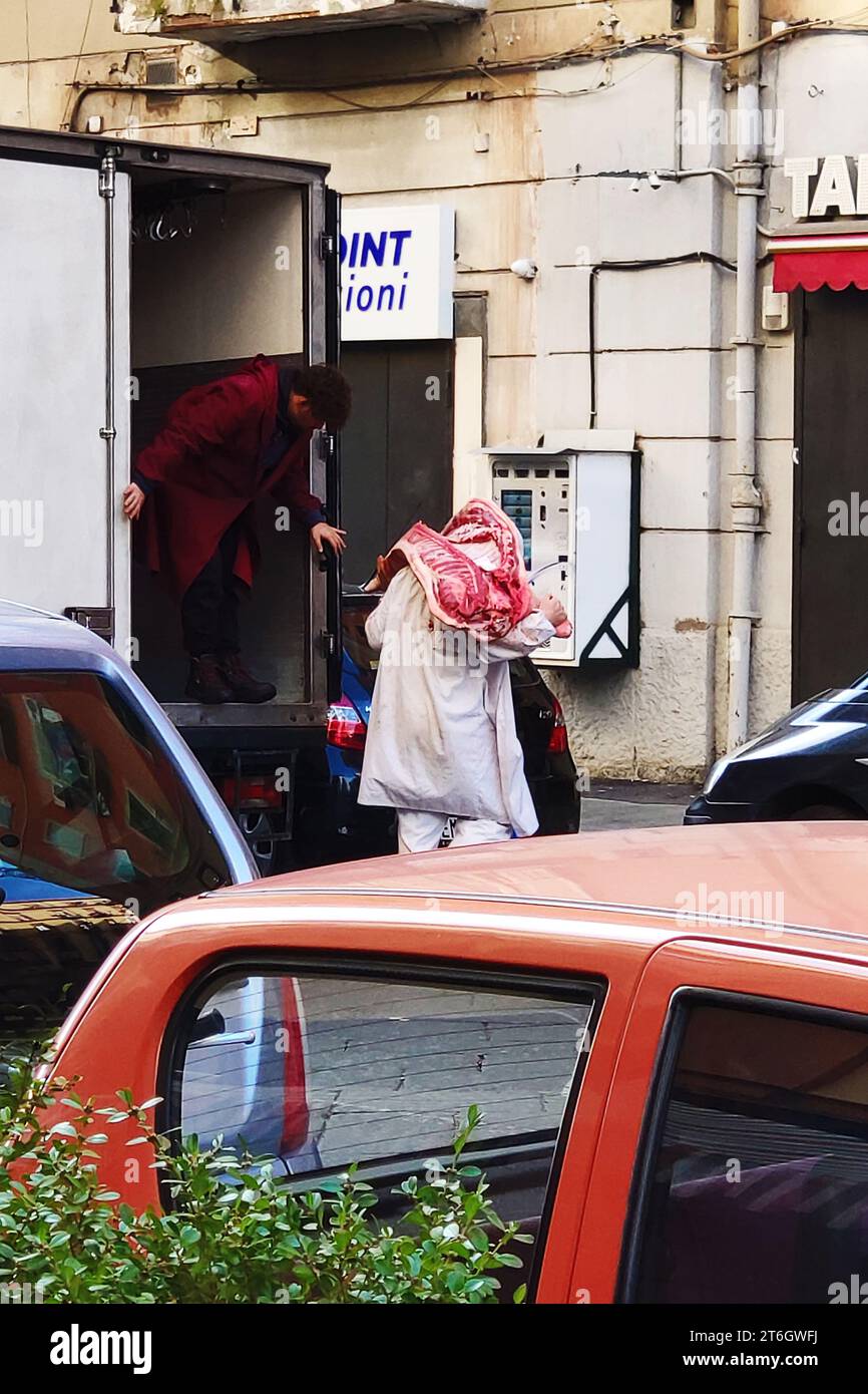 Meat arrives in the city center for the butcher shop, Two men unload ...