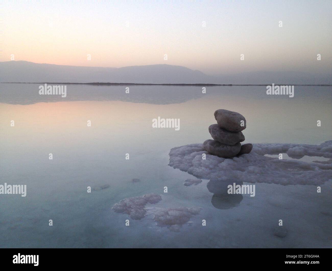 Stack of rocks piled up on a mound of salt at sunset, Dead Sea, Israel ...