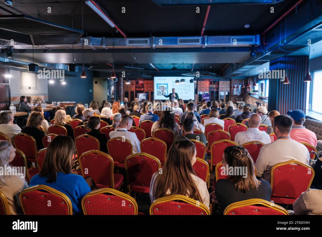 Back view of diverse business crowd attending international seminar in ...