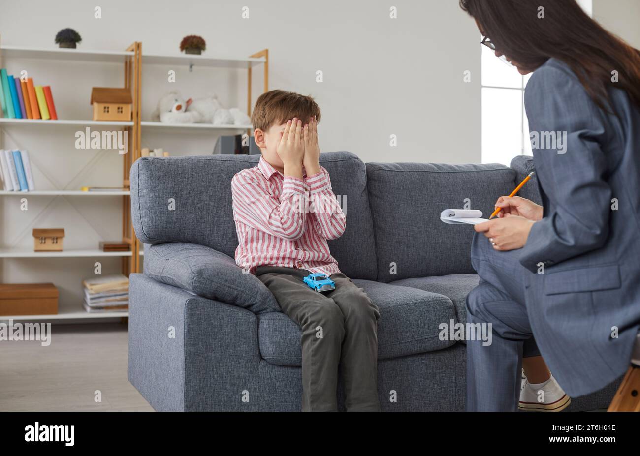Psychologist trying to help a little child boy with his fears during ...