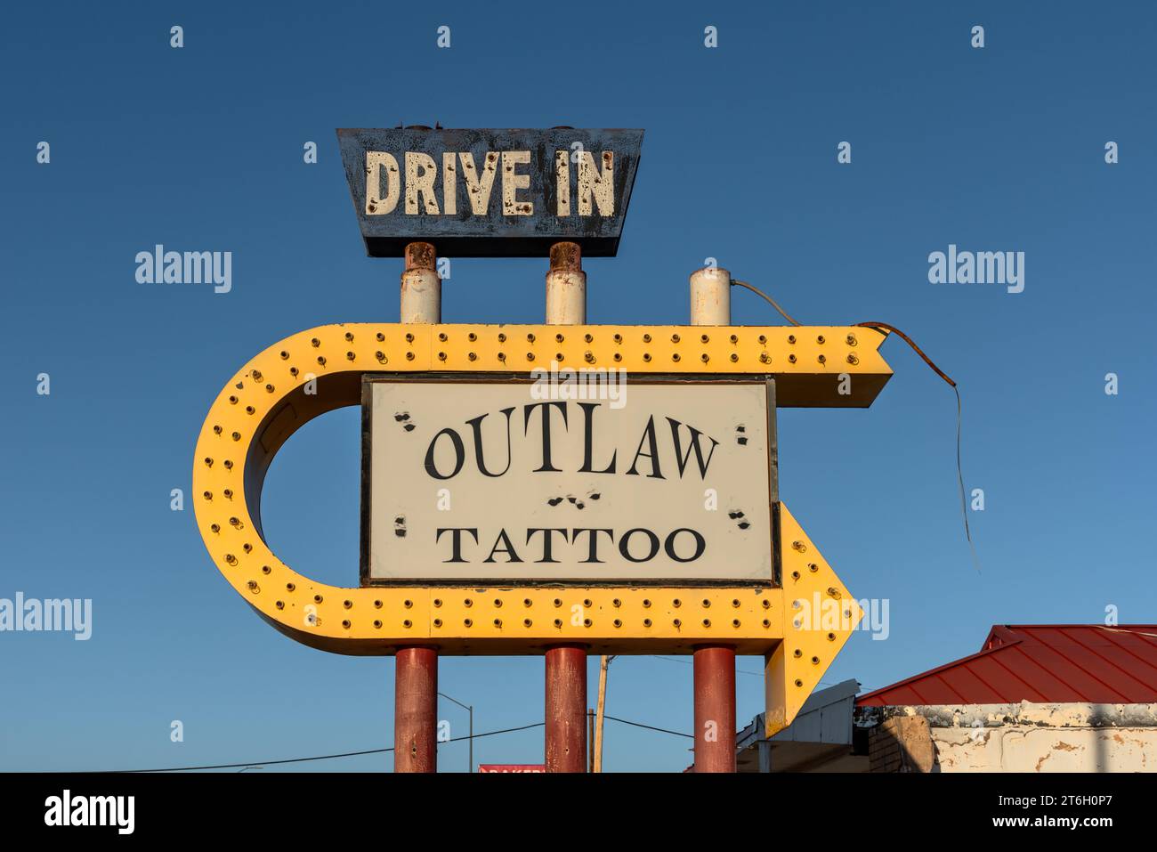 Sign, with large yellow arrow, for the Drive In Outlaw Tattoo, no ...