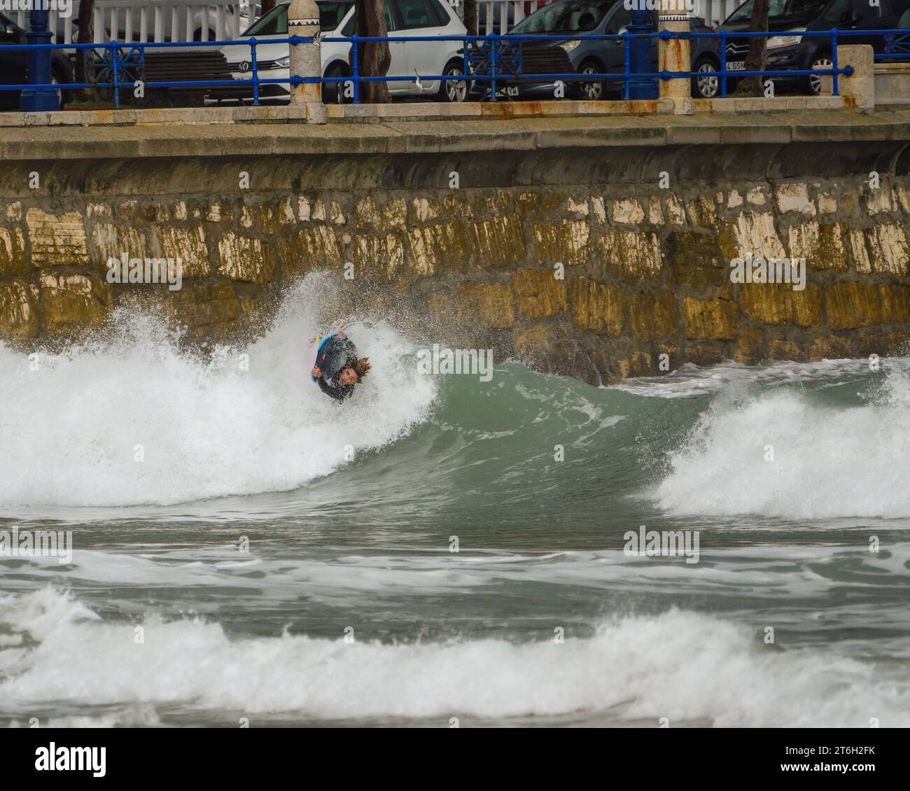 Surfing on Santander beach next to the pier Stock Photo - Alamy