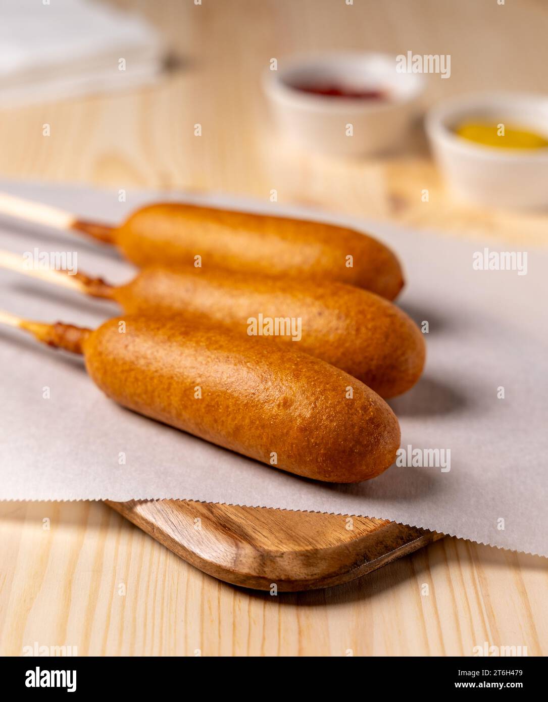Deep fried corn dogs on parchment paper with ketchup and mustard in the ...