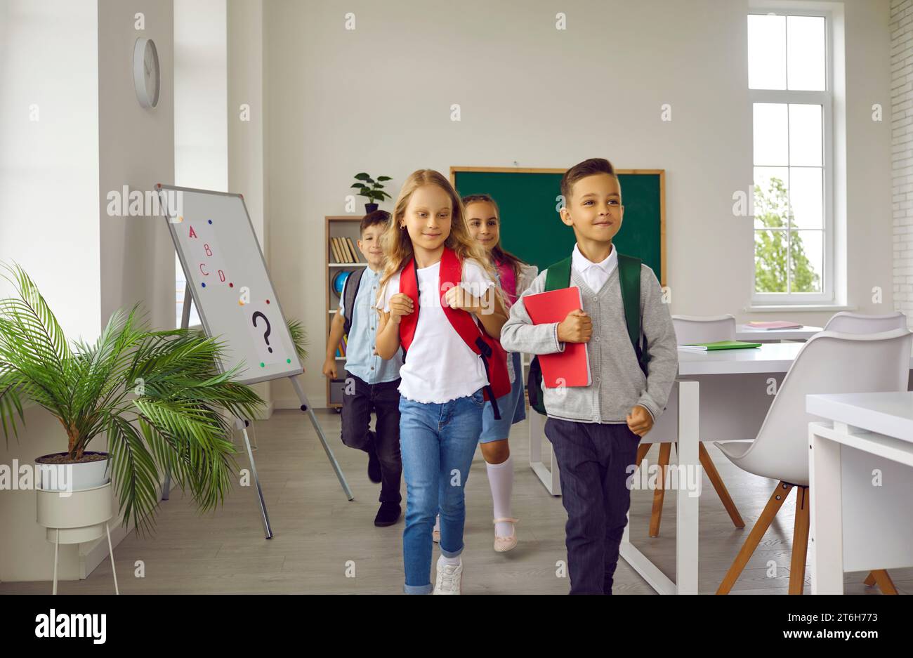 Funny elementary school students walking out of classroom together after lesson Stock Photo - Alamy