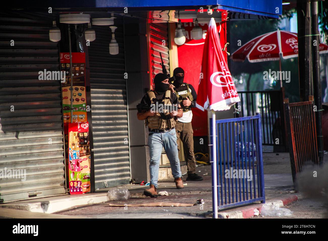 Masked Palestinian gunmen take cover during a bloody raid at Jenin ...