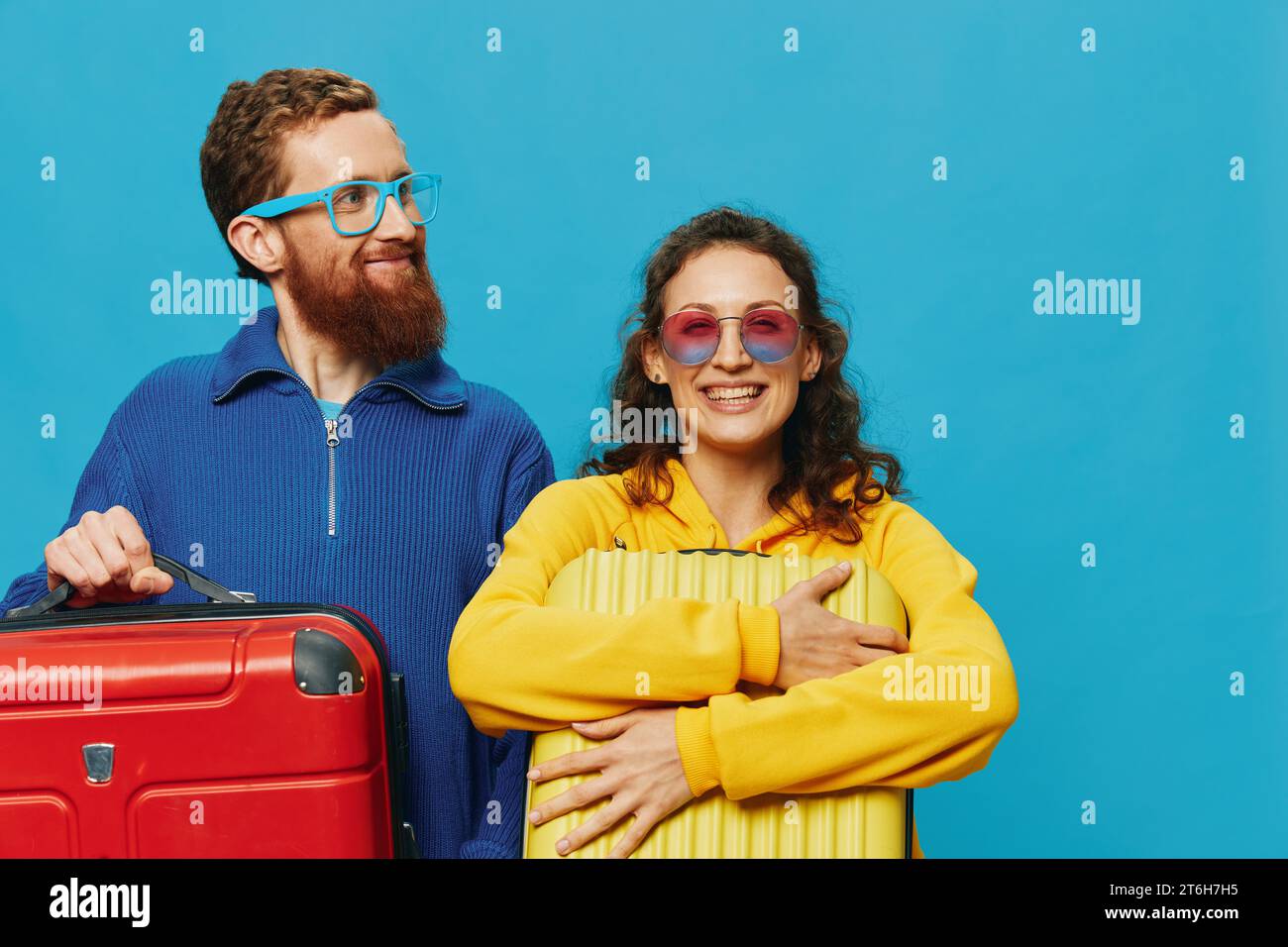Woman and man smile suitcases in hand with yellow and red suitcase ...