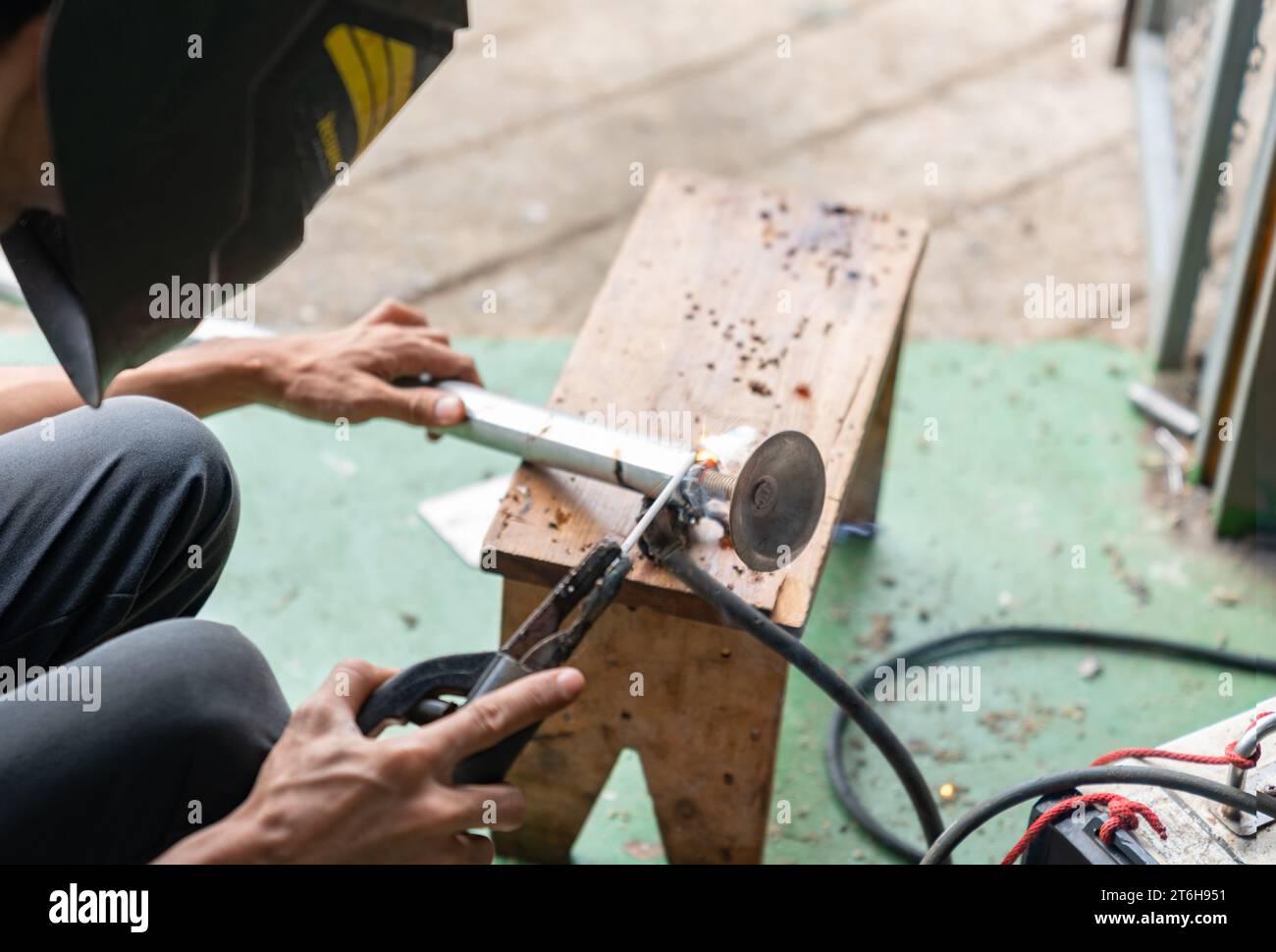 Technician welding foot adjustable table in workshop Stock Photo - Alamy