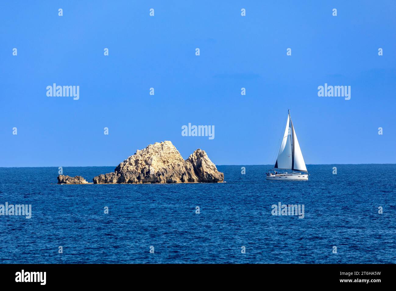 Sailing boat at a rock in the sea near Cala Rajada, island of Mallorca ...