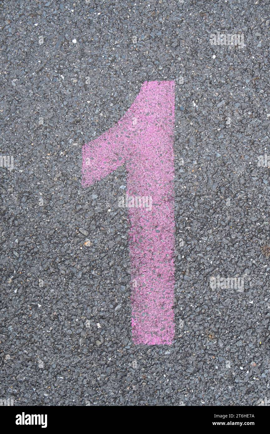 the number 1 one are drawn with color paint on asphalt. a children's ...
