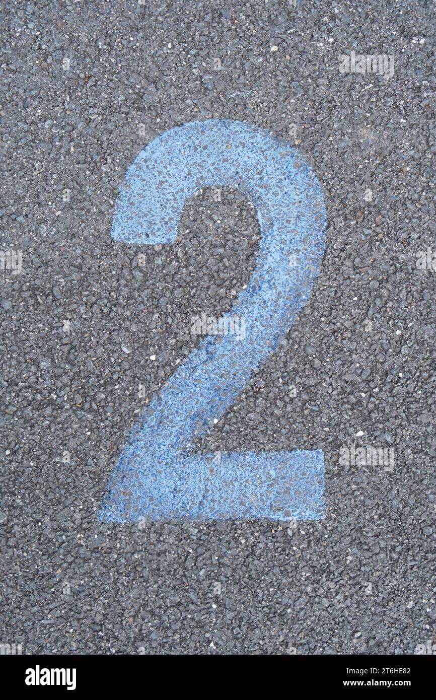 the number 2 two are drawn with color paint on asphalt. a children's ...