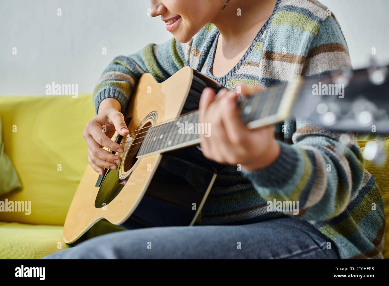 cropped view of young woman with piercing and tattoo learning how to ...