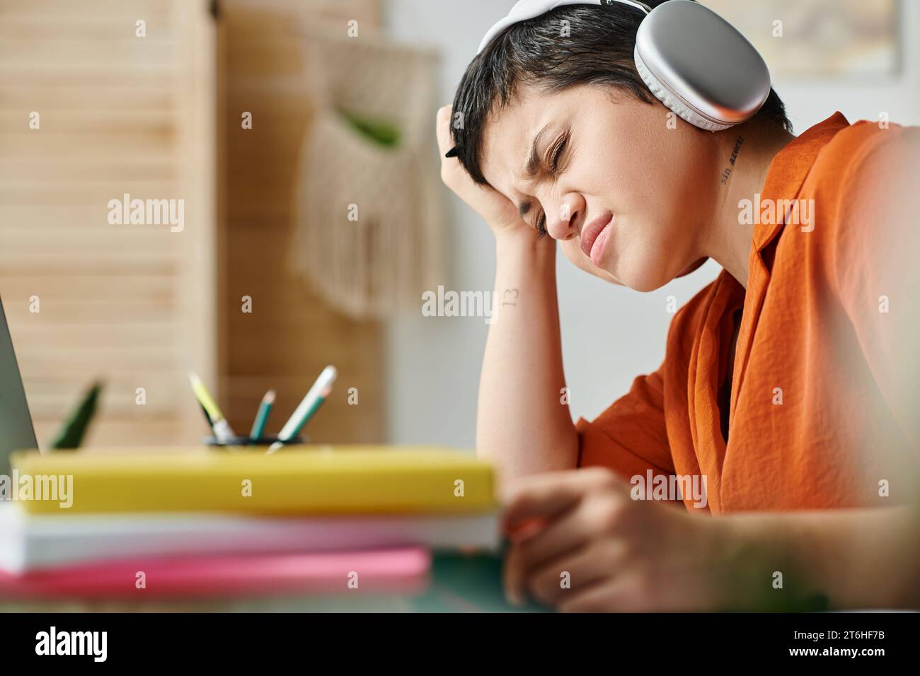 confused young brunette woman with tattoo on neck and headphones ...