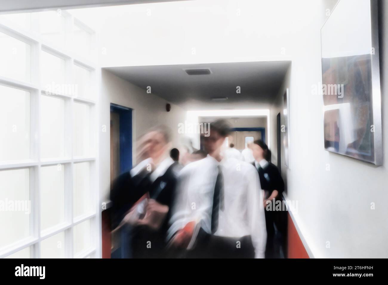 A motion blurred image of a group of pupils walking in the corridor at ...