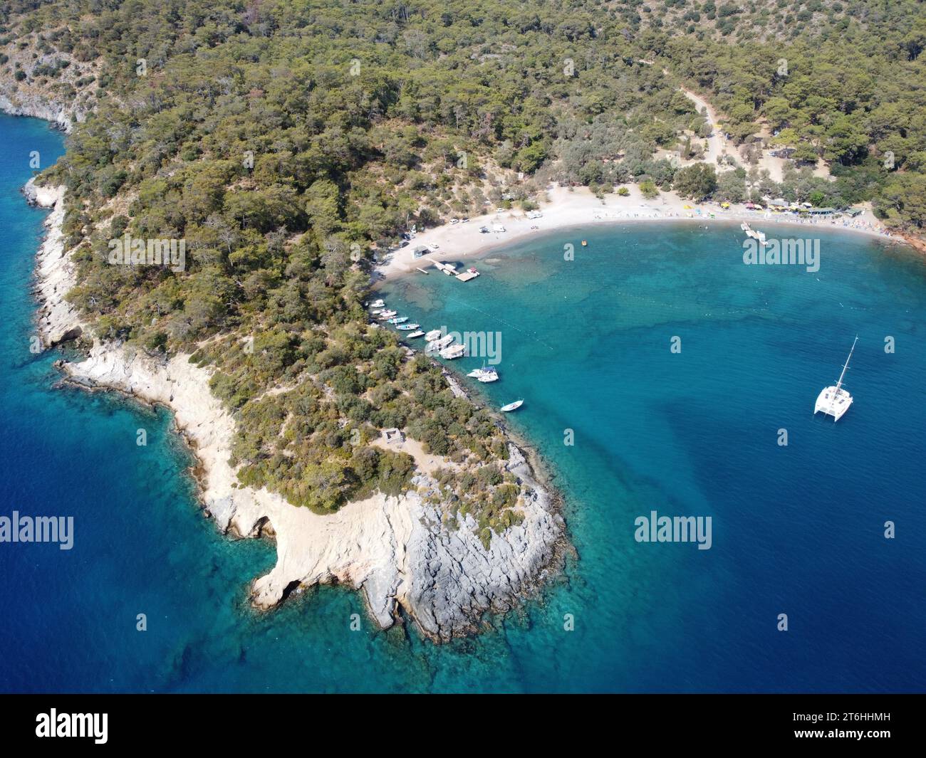 A cluster of sailboats docked in the tranquil blue waters of a small ...