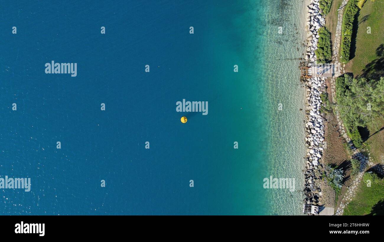 A breathtaking aerial view of a sun-kissed beach with pristine blue ...