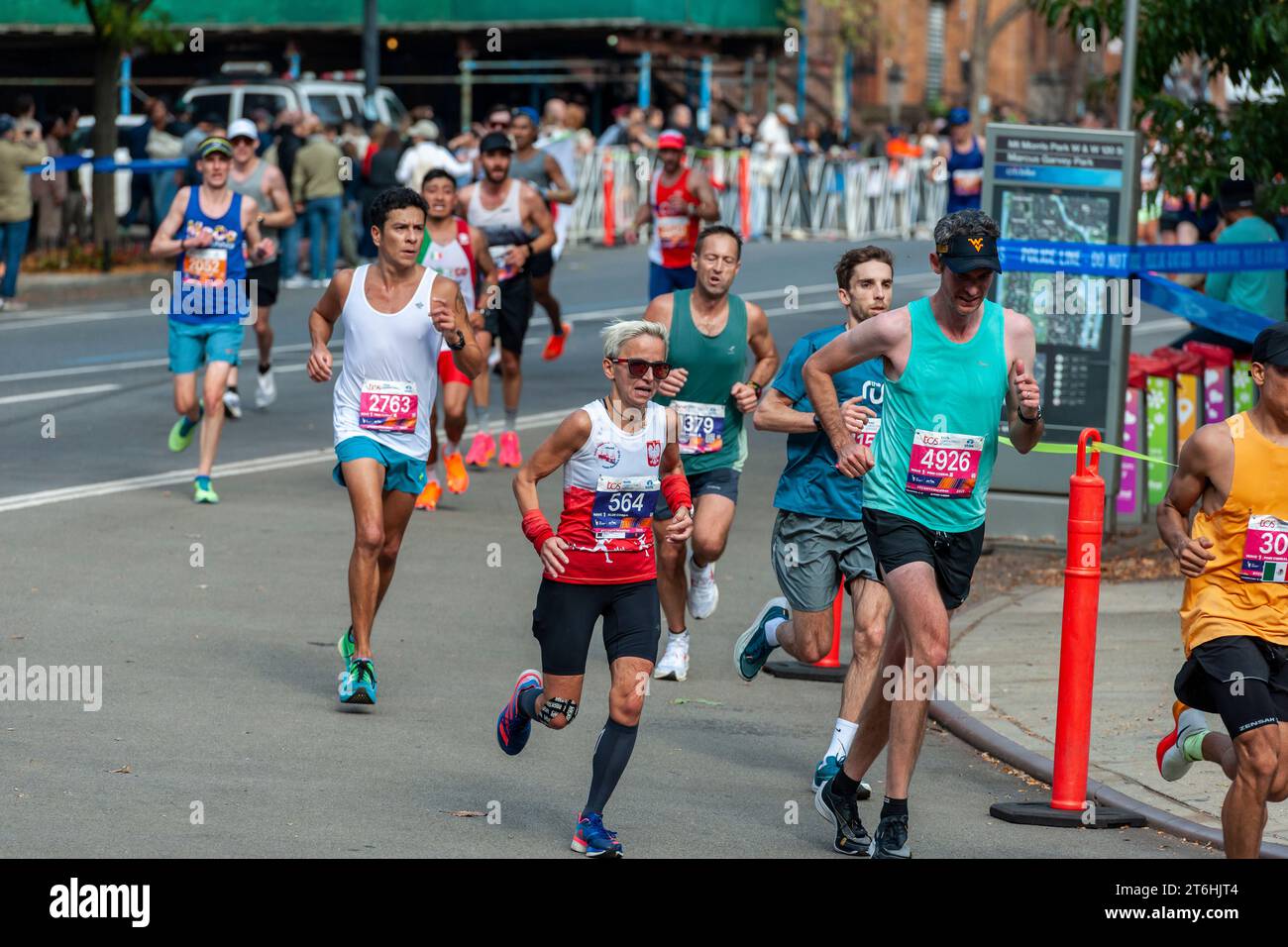 Runners pass through Harlem in New York near the 22 mile mark near ...