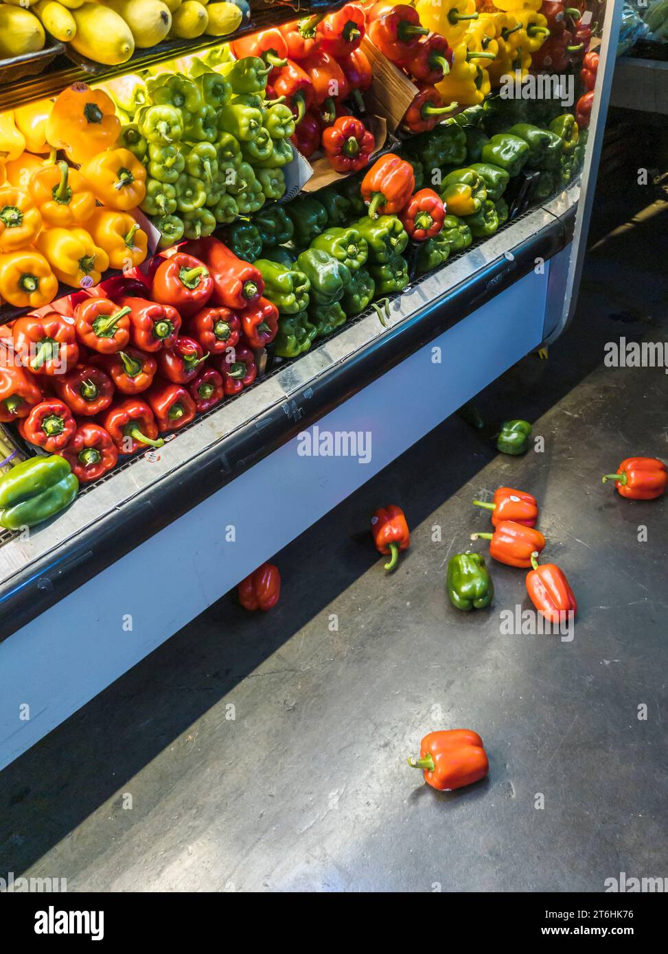 A display of peppers, some spilled, in the produce department of a ...