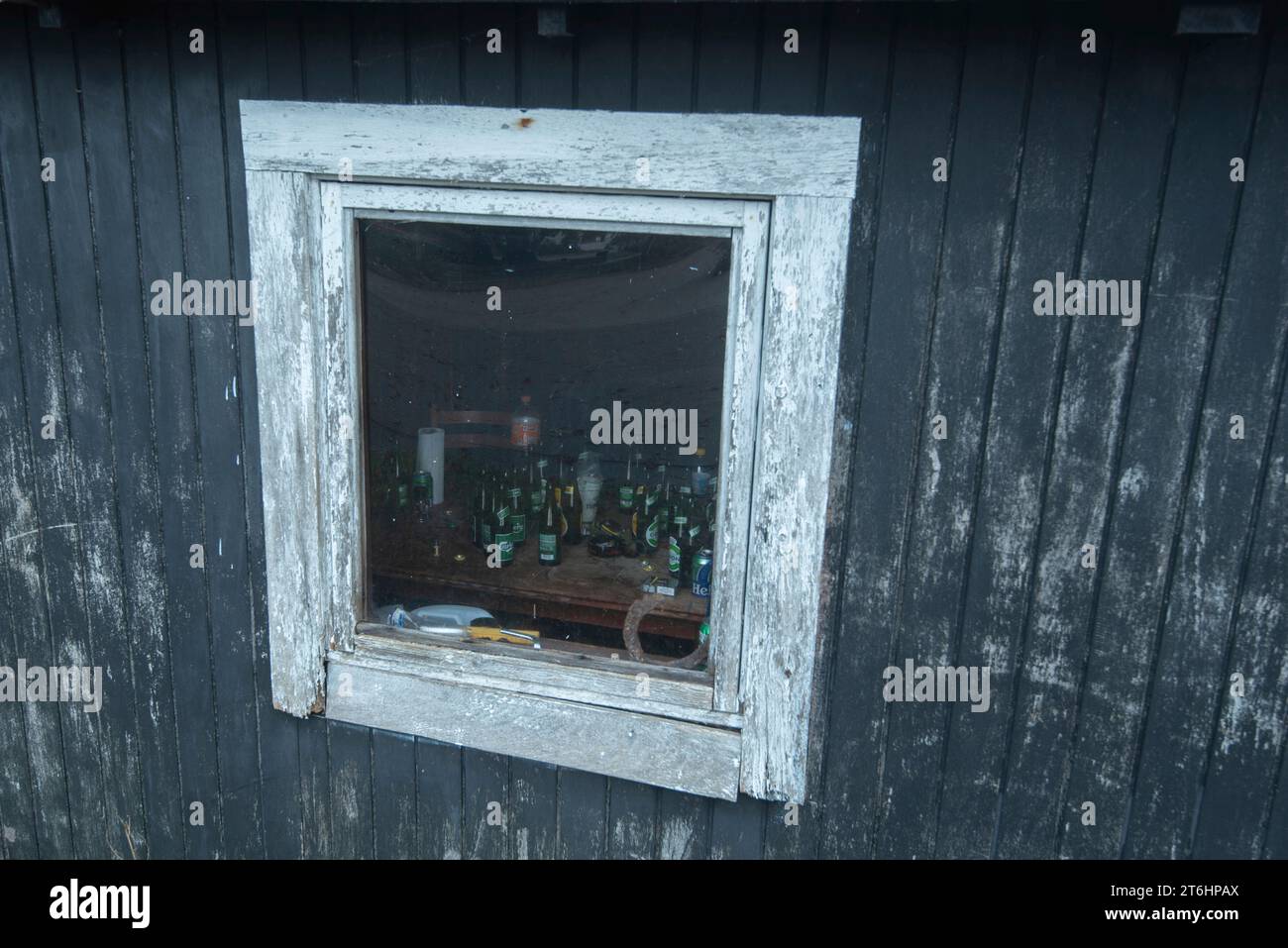 Beer bottles and cigarette packets behind the window of an old fishing ...