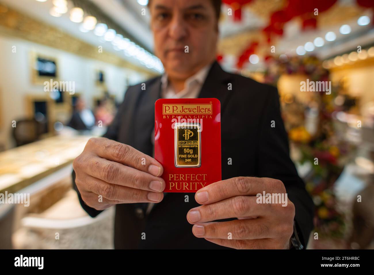 New Delhi, India. 10th Nov, 2023. A salesman showcasing a 50 gram 24 ...
