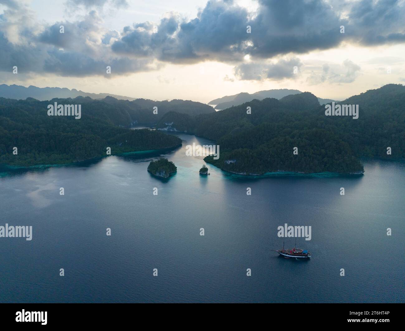 Rugged, jungle-covered islands surround a calm, narrow channel in Alyui ...