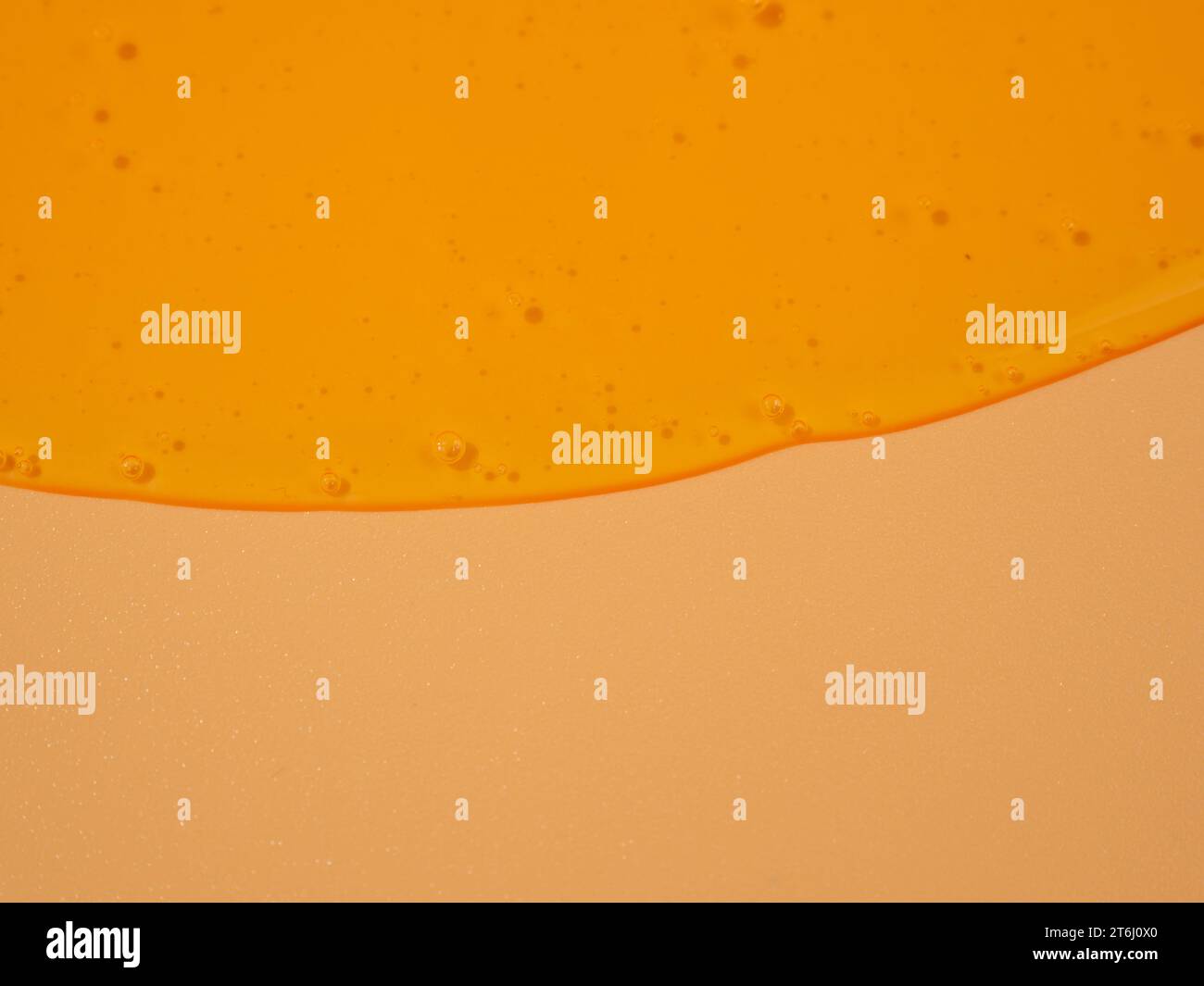 Liquid shower gel flows gracefully across a bright orange background ...