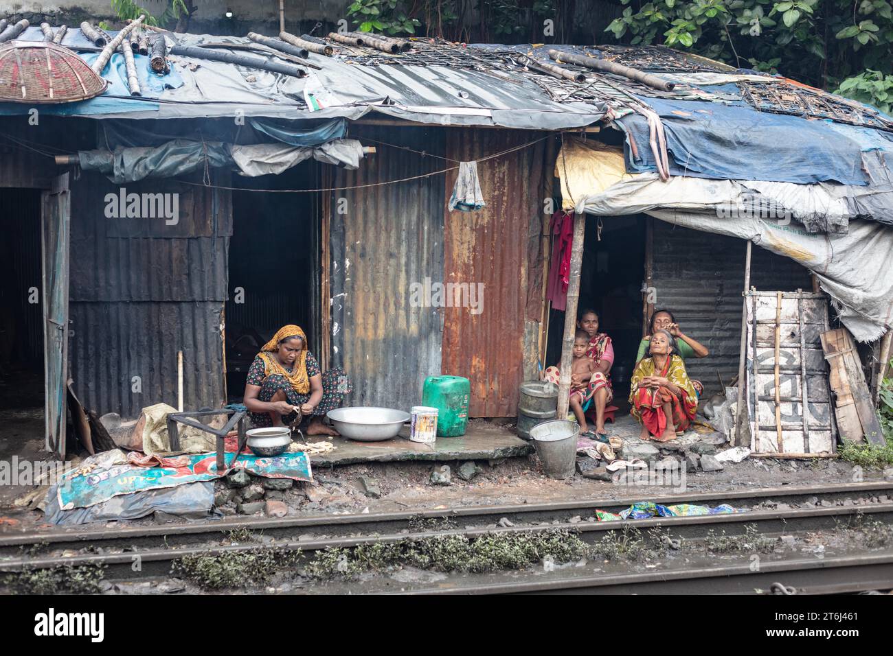 Women in front of their houses built directly on the railway tracks ...