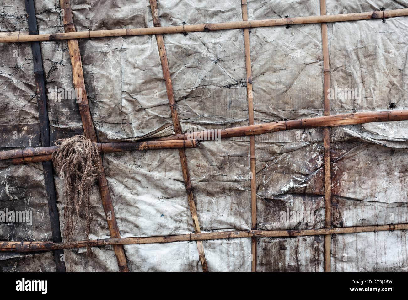 Detail of a makeshift dwelling made of plastic sheeting and bamboo ...