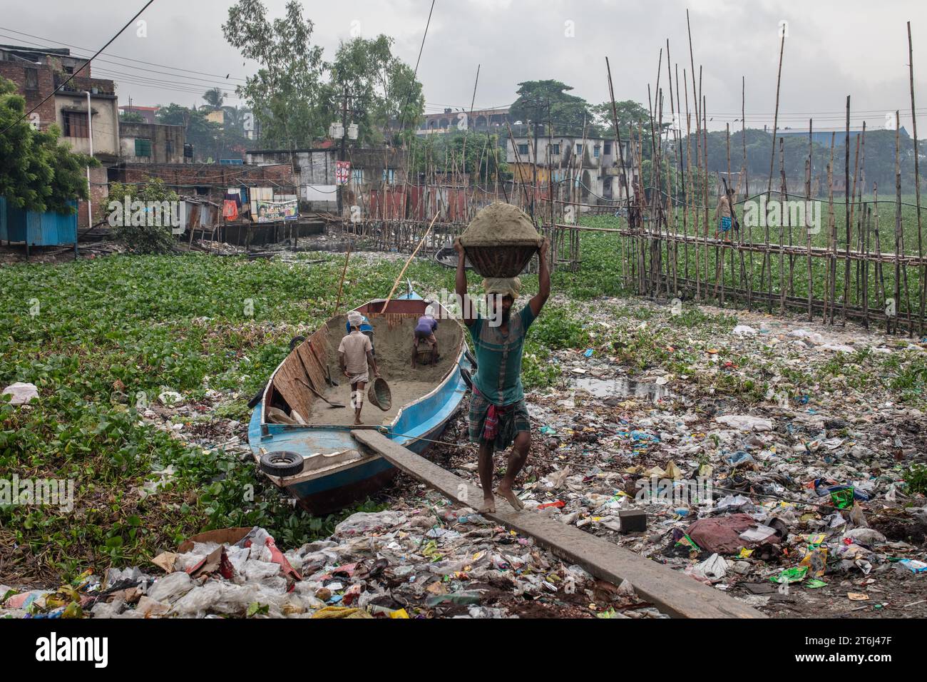 Construction workers transporting sand from a boat over a plank, Tel ...