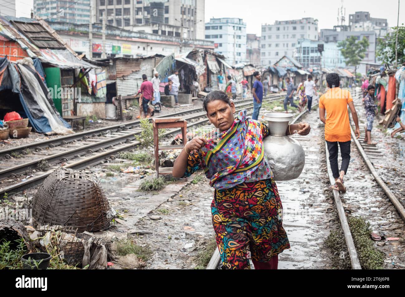 Woman carrying water on the railway tracks, Tejgaon Slum Area, Dhaka ...