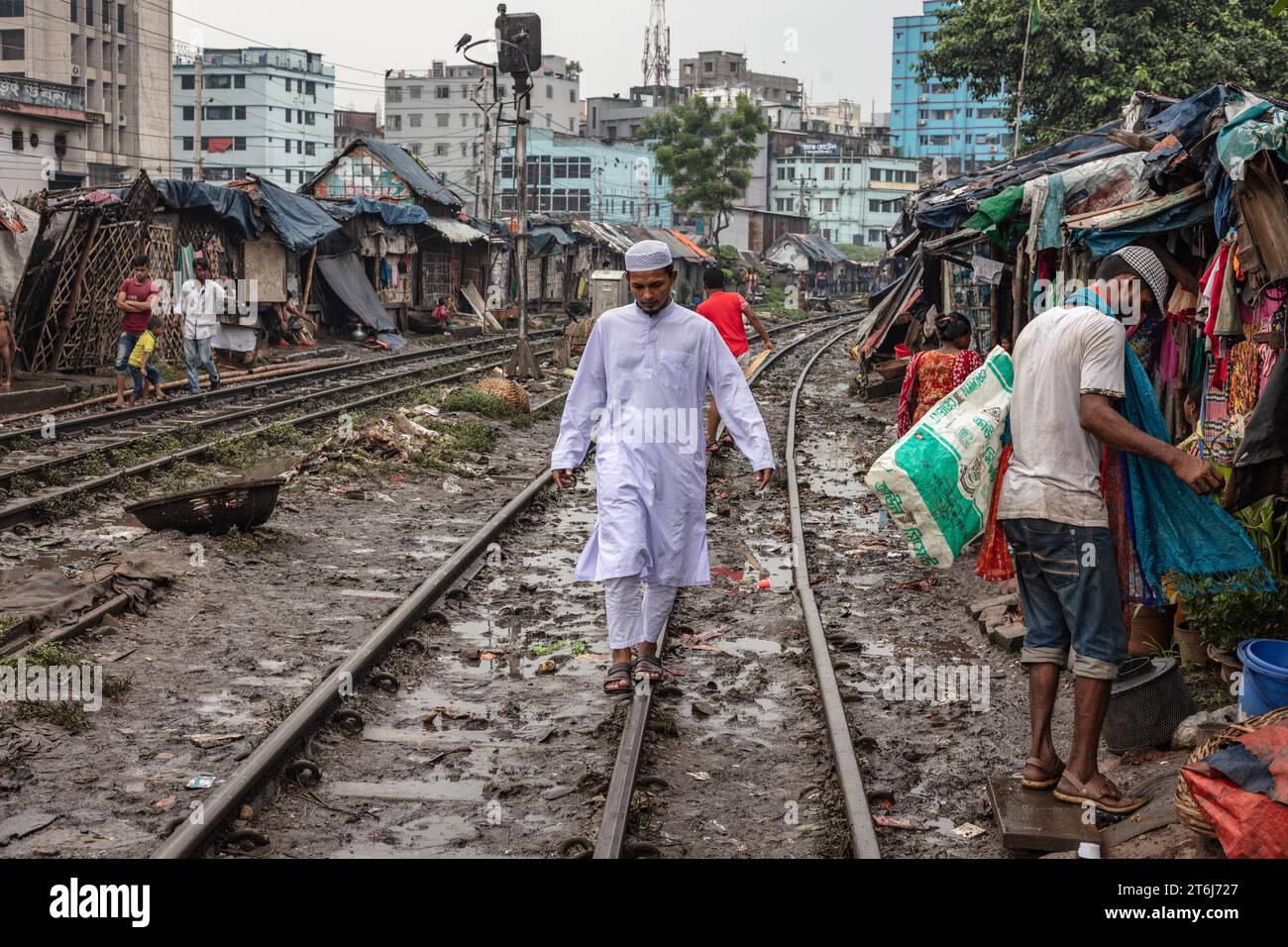 A man balances on the rail of a railway track, Tejgaon Slum Area, Dhaka ...