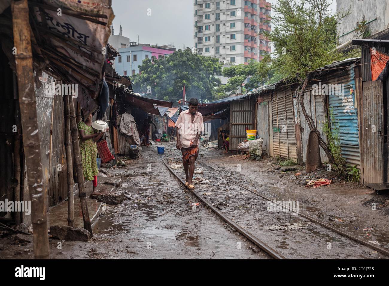 A man balances on a rail of a railway track, Tejgaon Slum Area, Dhaka ...